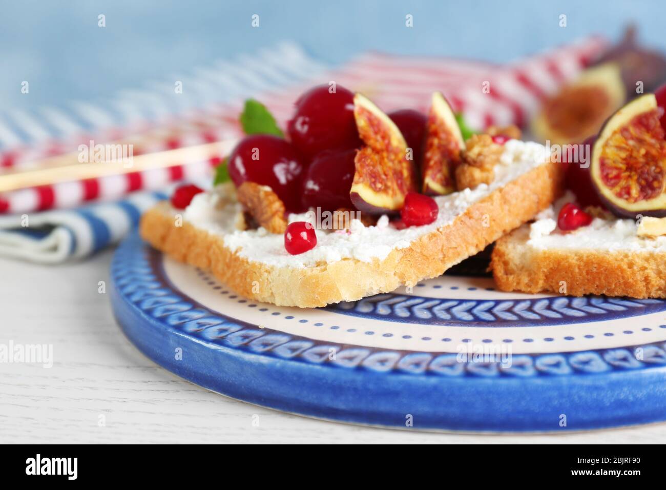 Delicious toasts with fruits on plate, closeup Stock Photo - Alamy