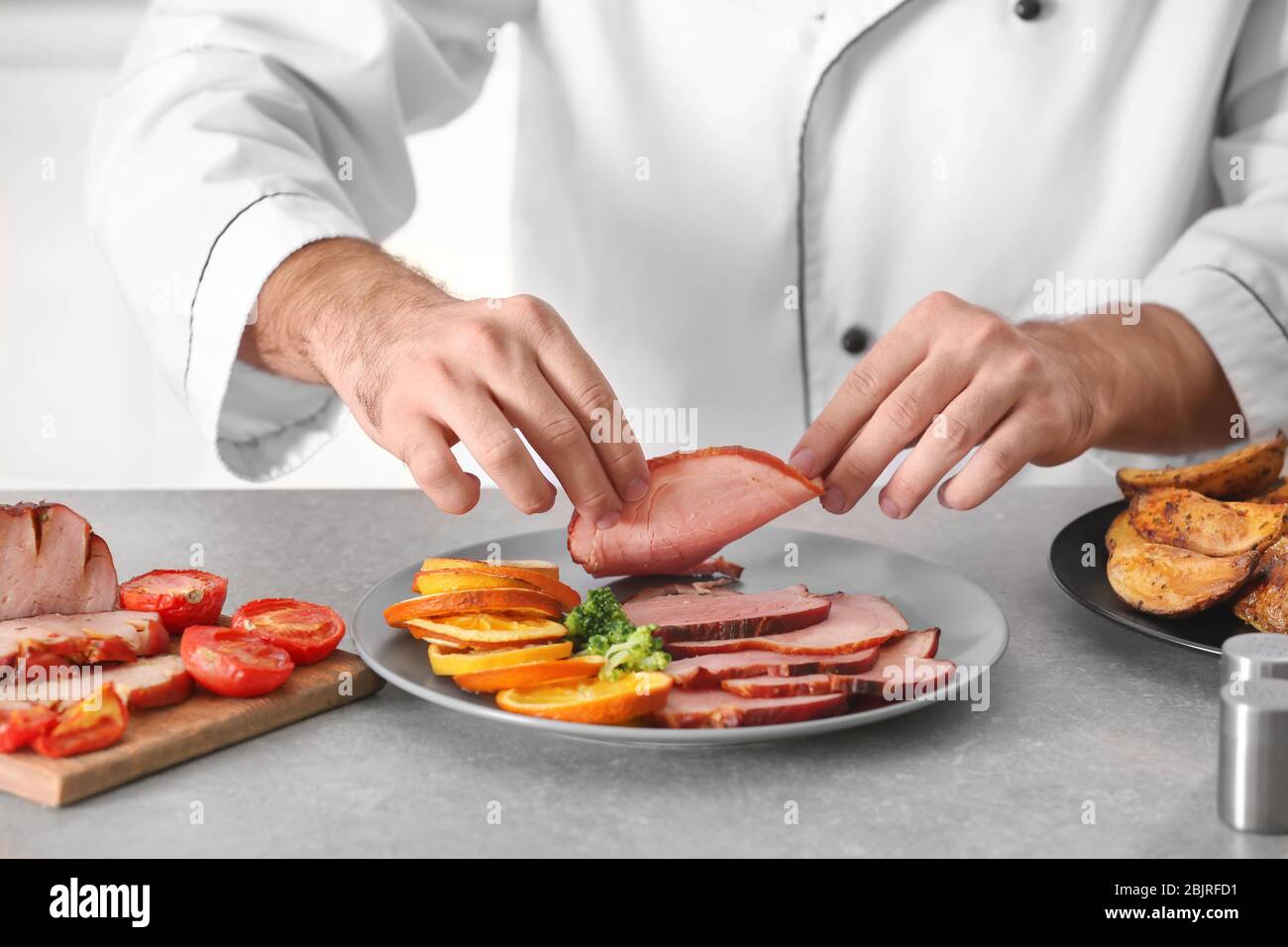 Chef serving delicious honey baked ham on plate Stock Photo - Alamy