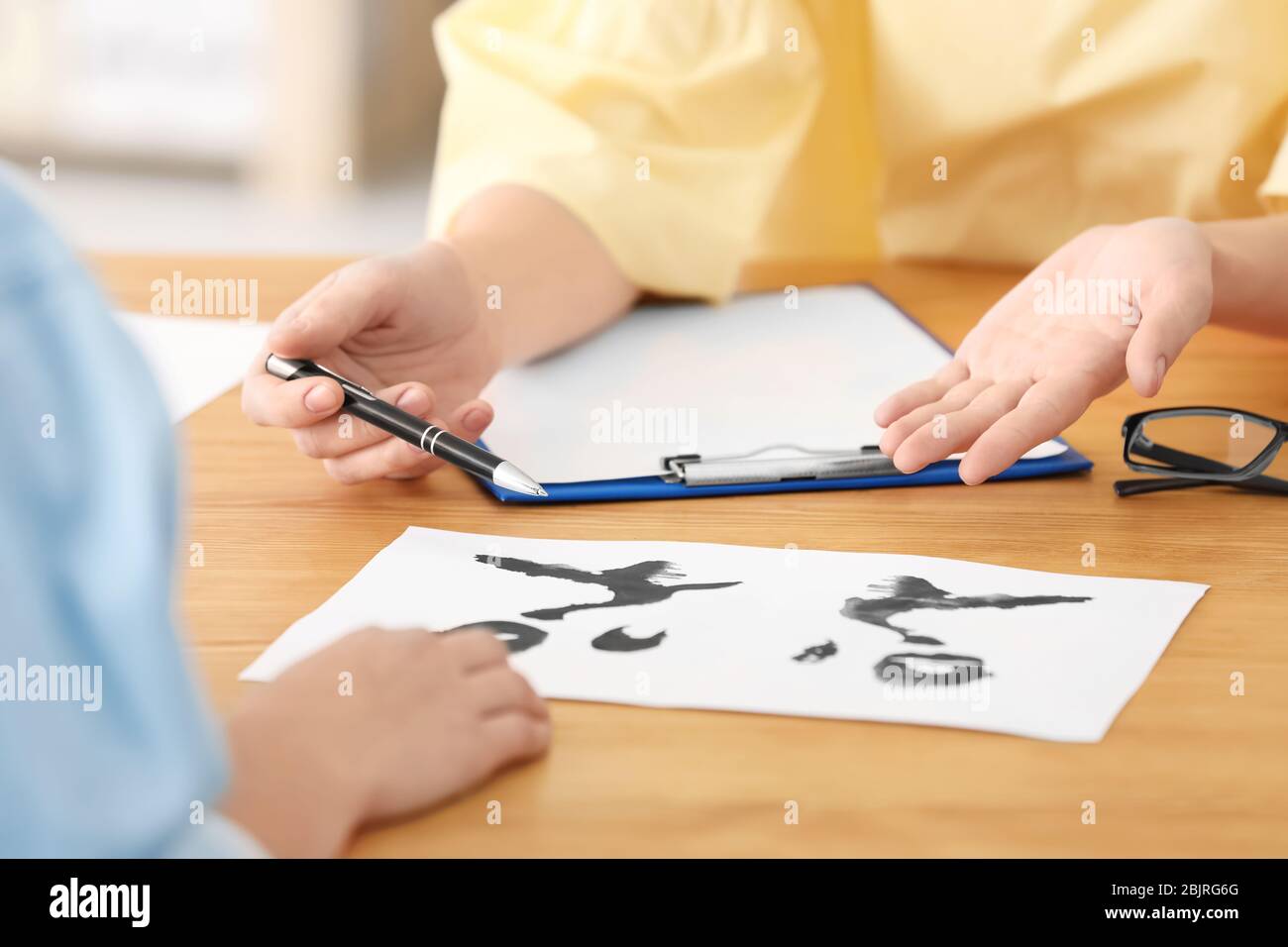 Female psychologist showing her patient picture for Rorschach test in ...