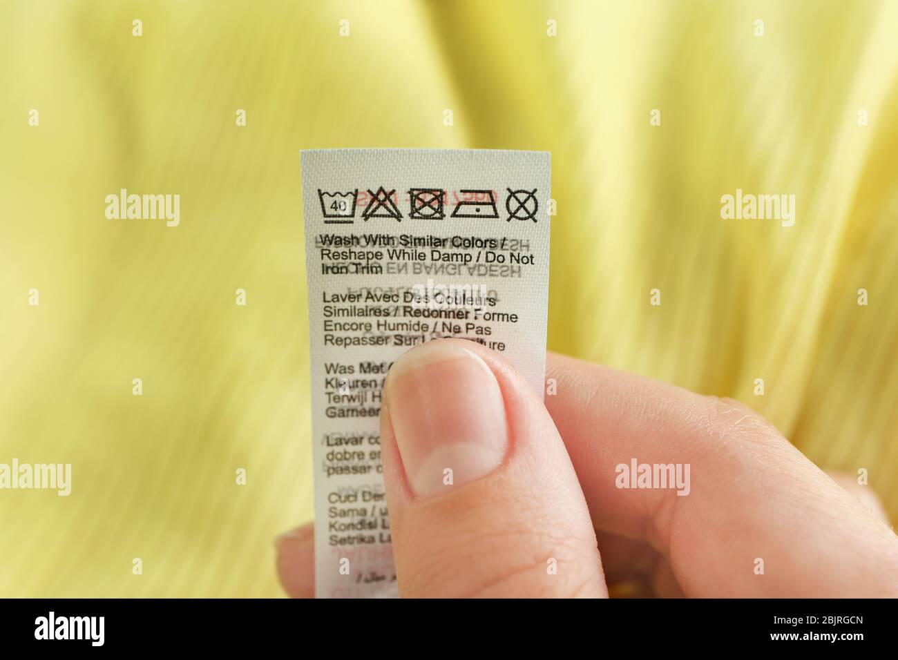 Woman reading instruction on clothing label, closeup Stock Photo - Alamy