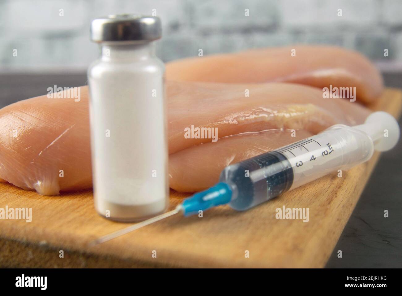 Injection syringe in raw chicken pieces, concept of injection of GMOs ...