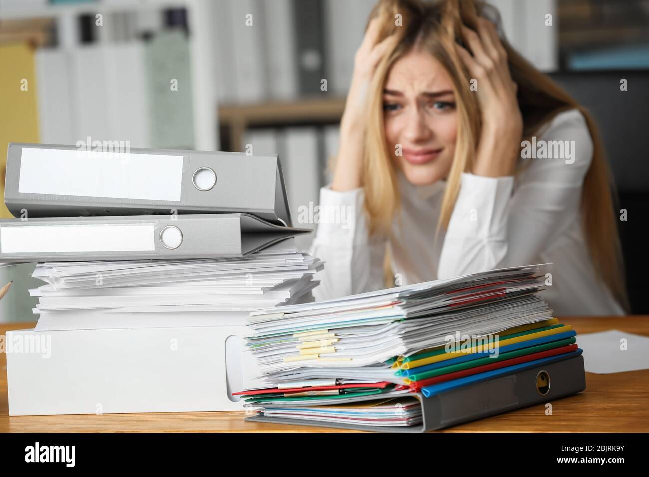 Emotional woman with stack of documents on her table in office Stock ...