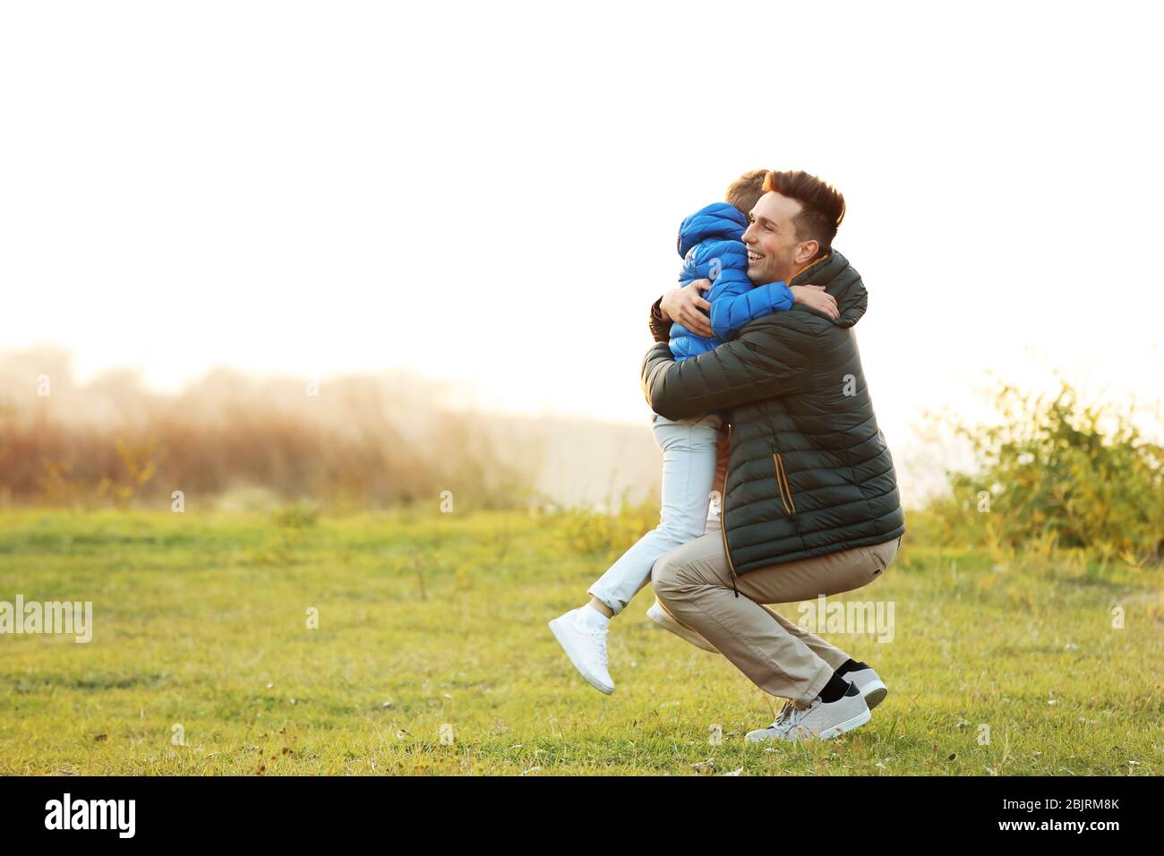 Little boy hugging his father outdoors Stock Photo - Alamy