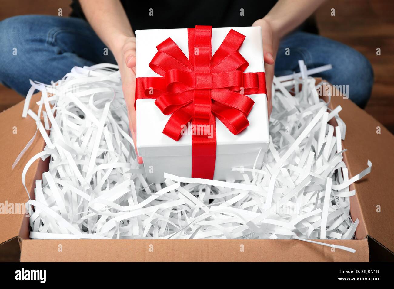 Woman taking gift box out of parcel indoors Stock Photo - Alamy
