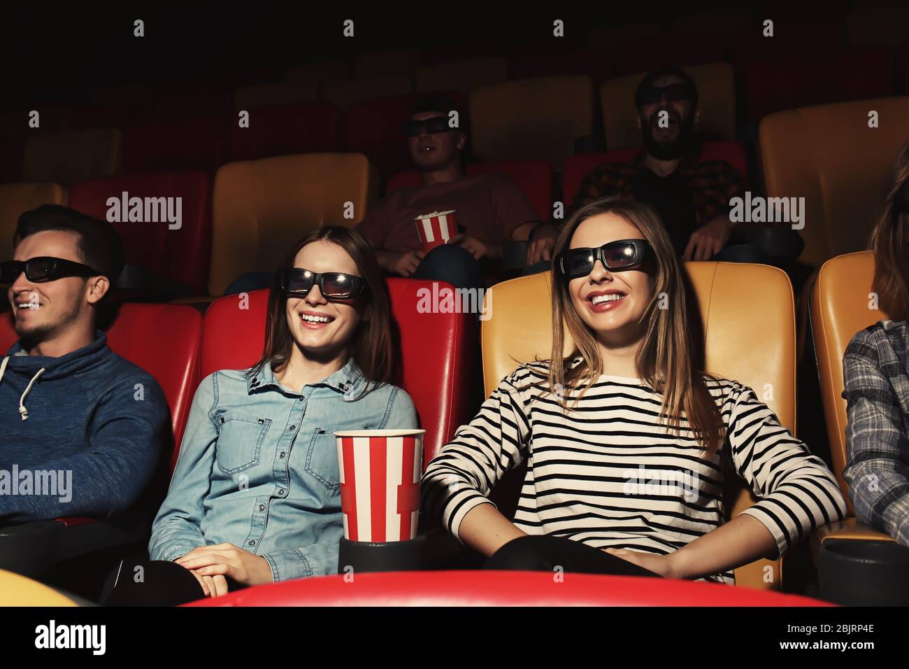 Young people watching movie in cinema Stock Photo - Alamy