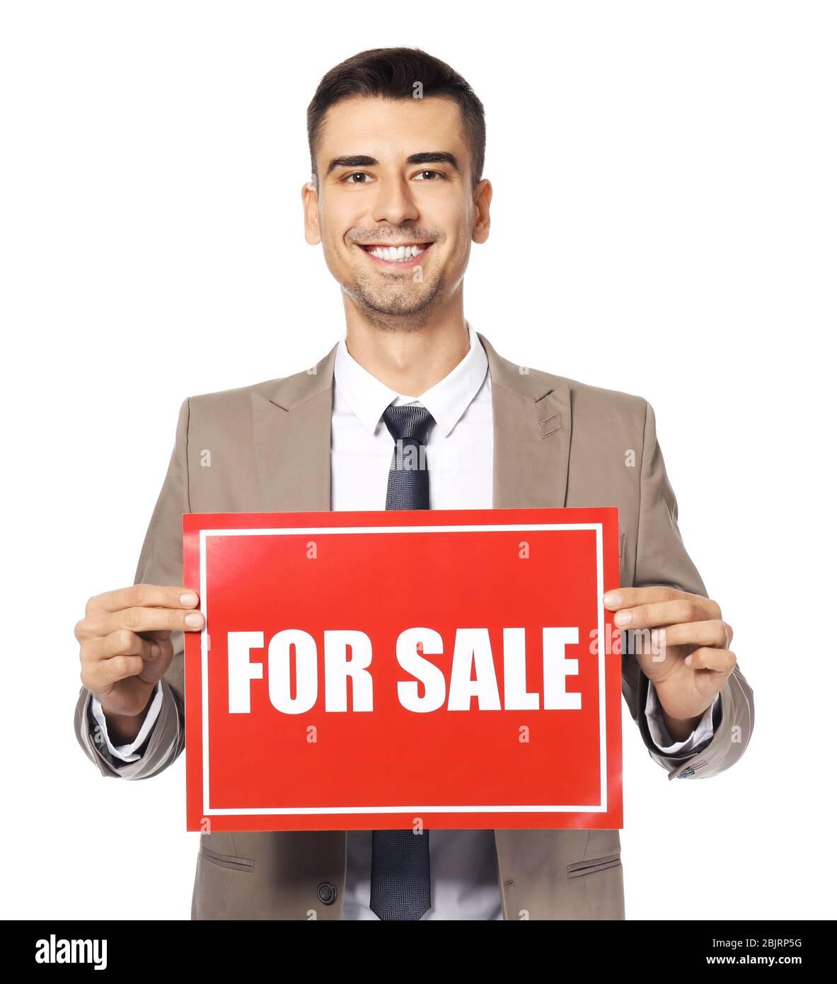 Attractive real estate agent holding "For sale" sign on white ...