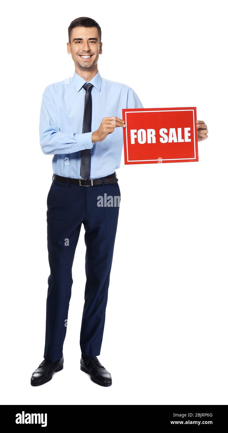 Attractive real estate agent holding "For sale" sign on white ...