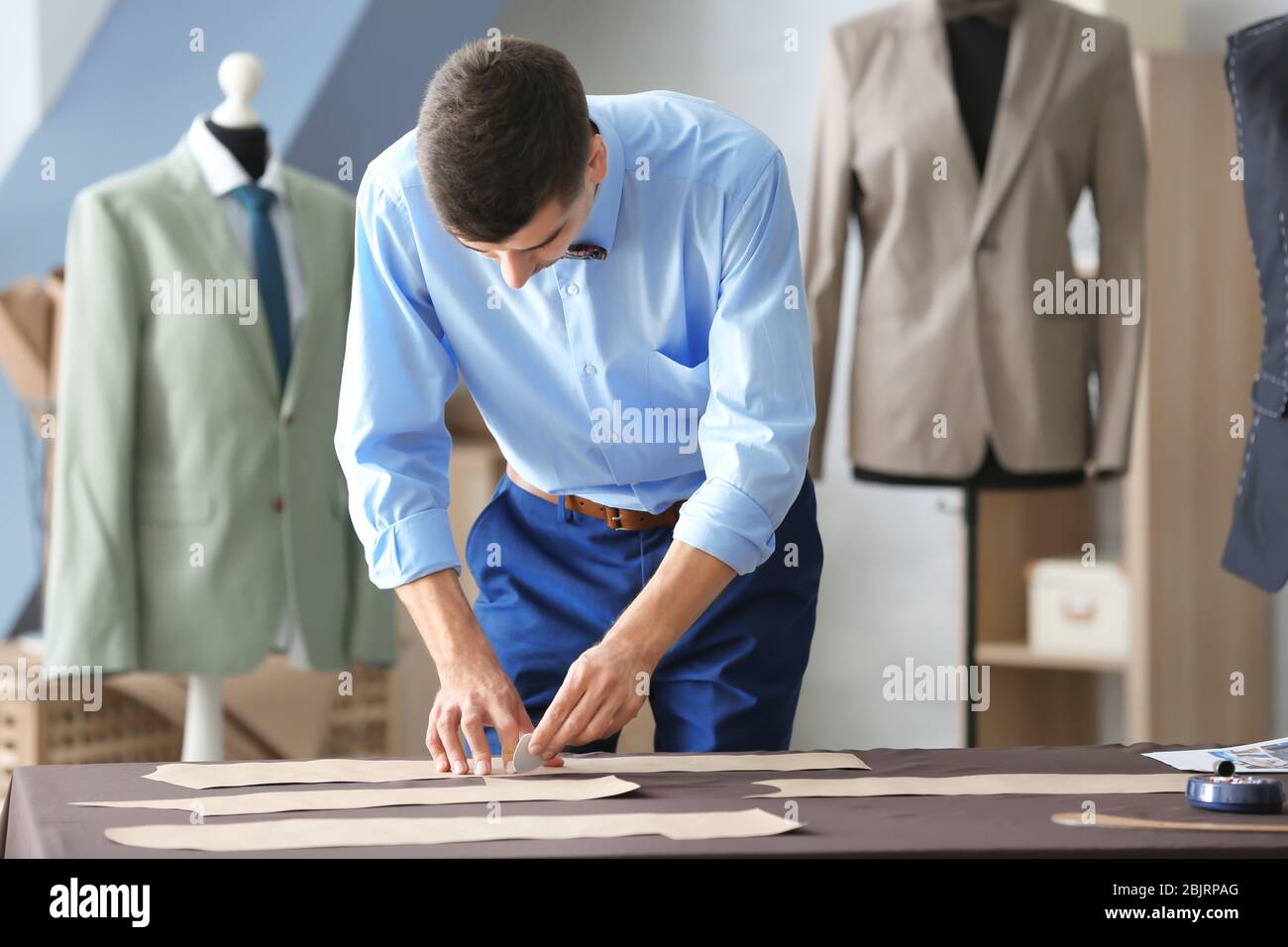 Young tailor working with sewing pattern in atelier Stock Photo - Alamy