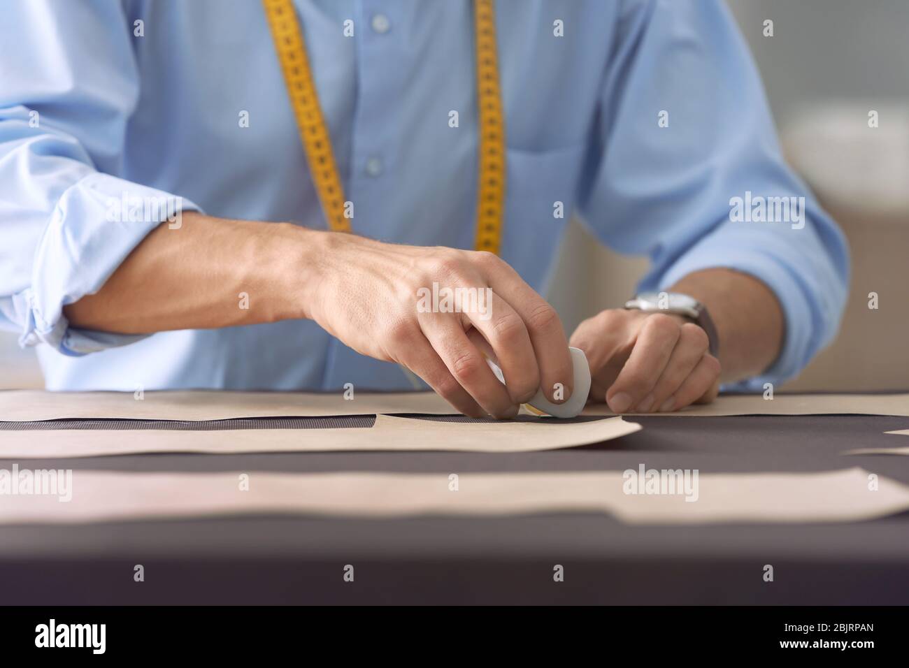 Young tailor working with sewing pattern, closeup Stock Photo - Alamy