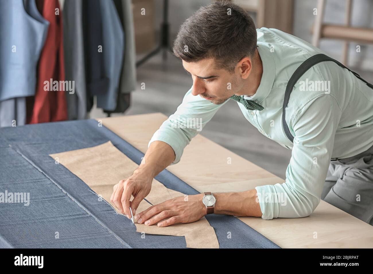 Young tailor working with sewing pattern in atelier Stock Photo - Alamy