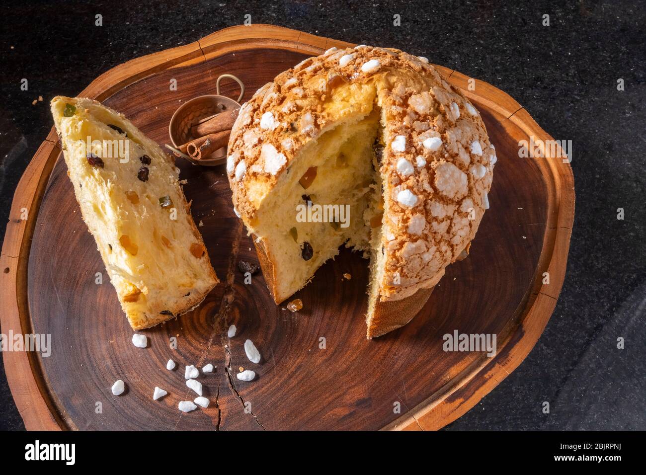 slice of handmade panettone decorated with pieces of sugar on wooden ...