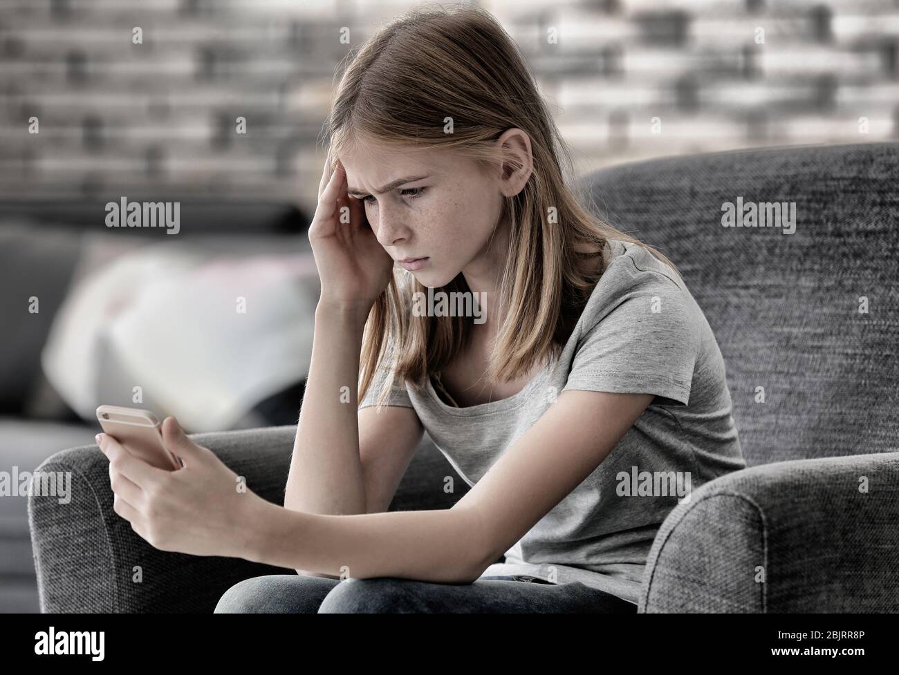Sad teenage girl with smartphone at home Stock Photo - Alamy