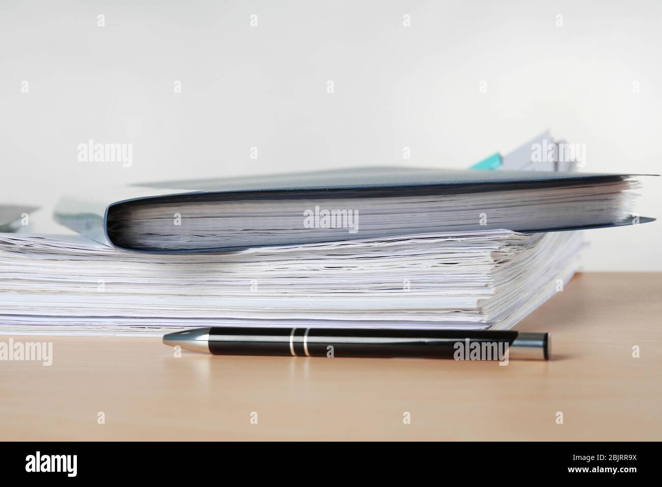 Stack of documents on table against light background Stock Photo - Alamy