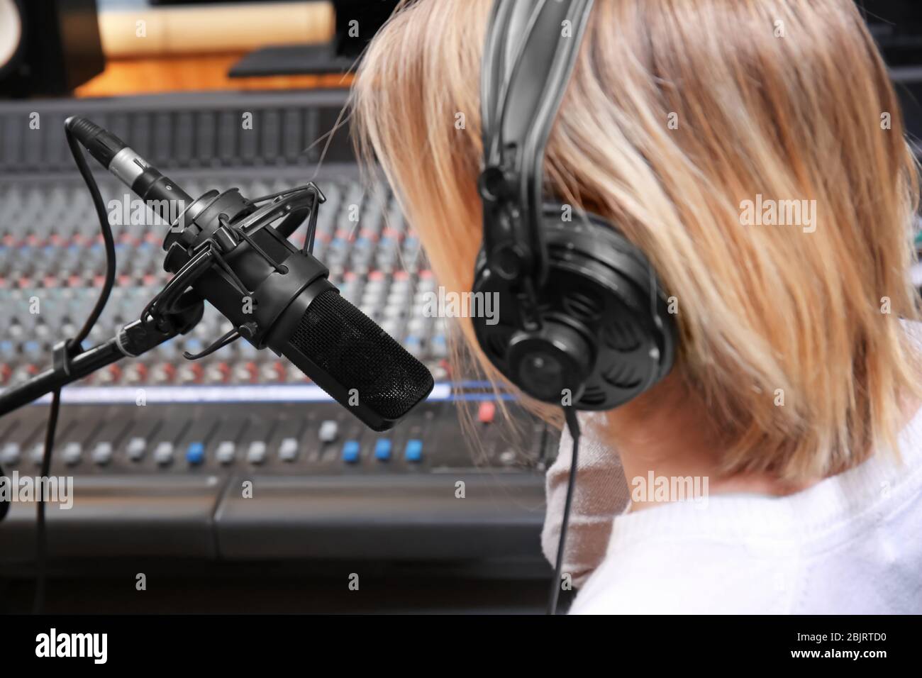Female radio host broadcasting through microphone in studio Stock Photo ...