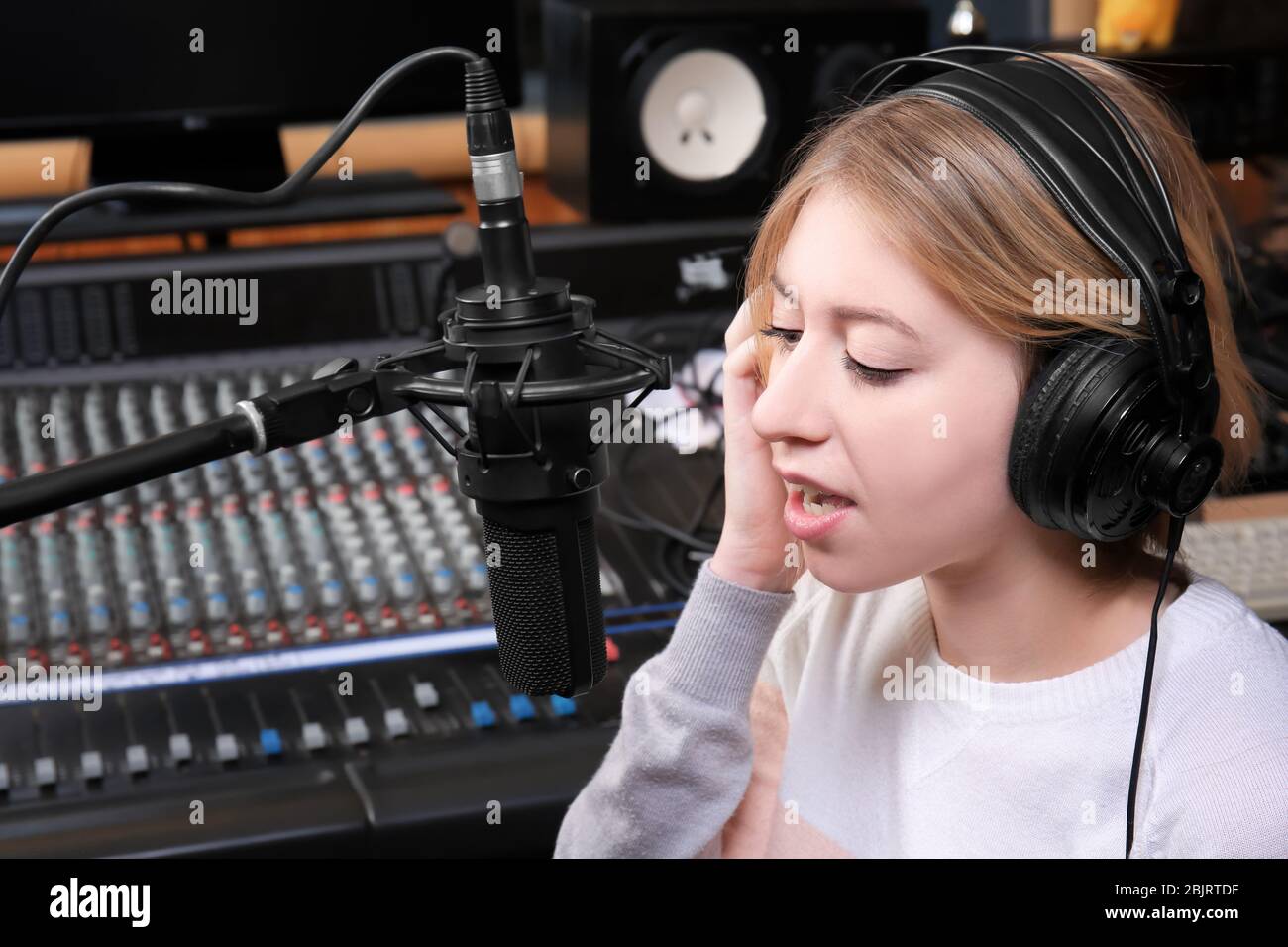 Female radio host broadcasting through microphone in studio Stock Photo ...