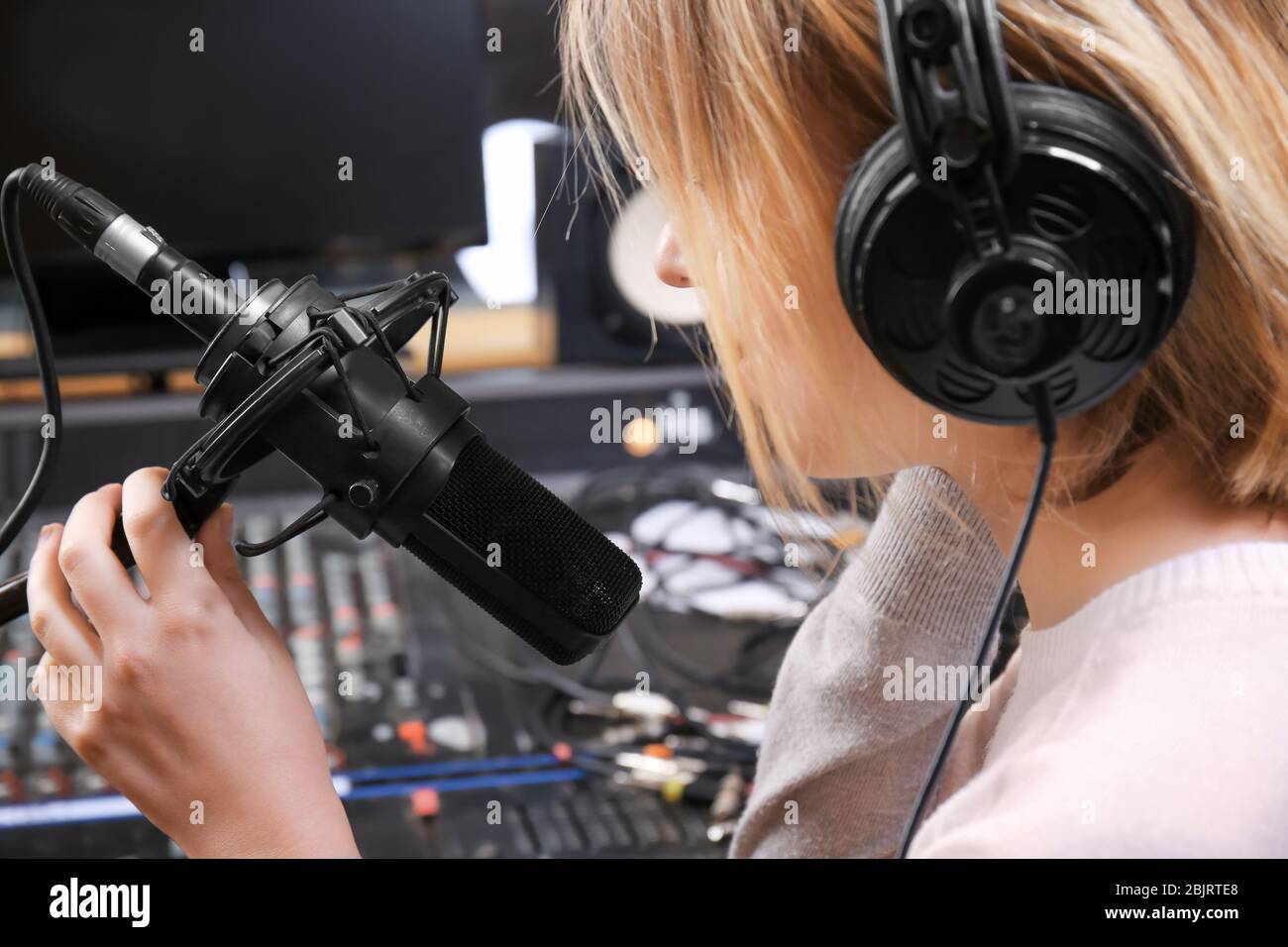 Female radio host broadcasting through microphone in studio Stock Photo ...