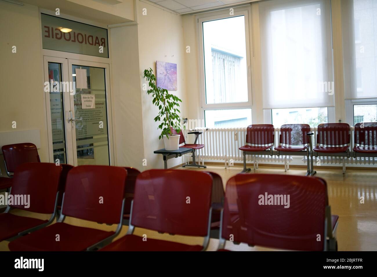 Waiting room with red chairs and beige linoleum floor Stock Photo - Alamy