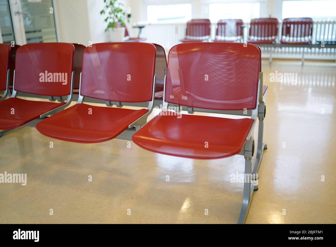 Waiting room with red chairs and beige linoleum floor Stock Photo - Alamy