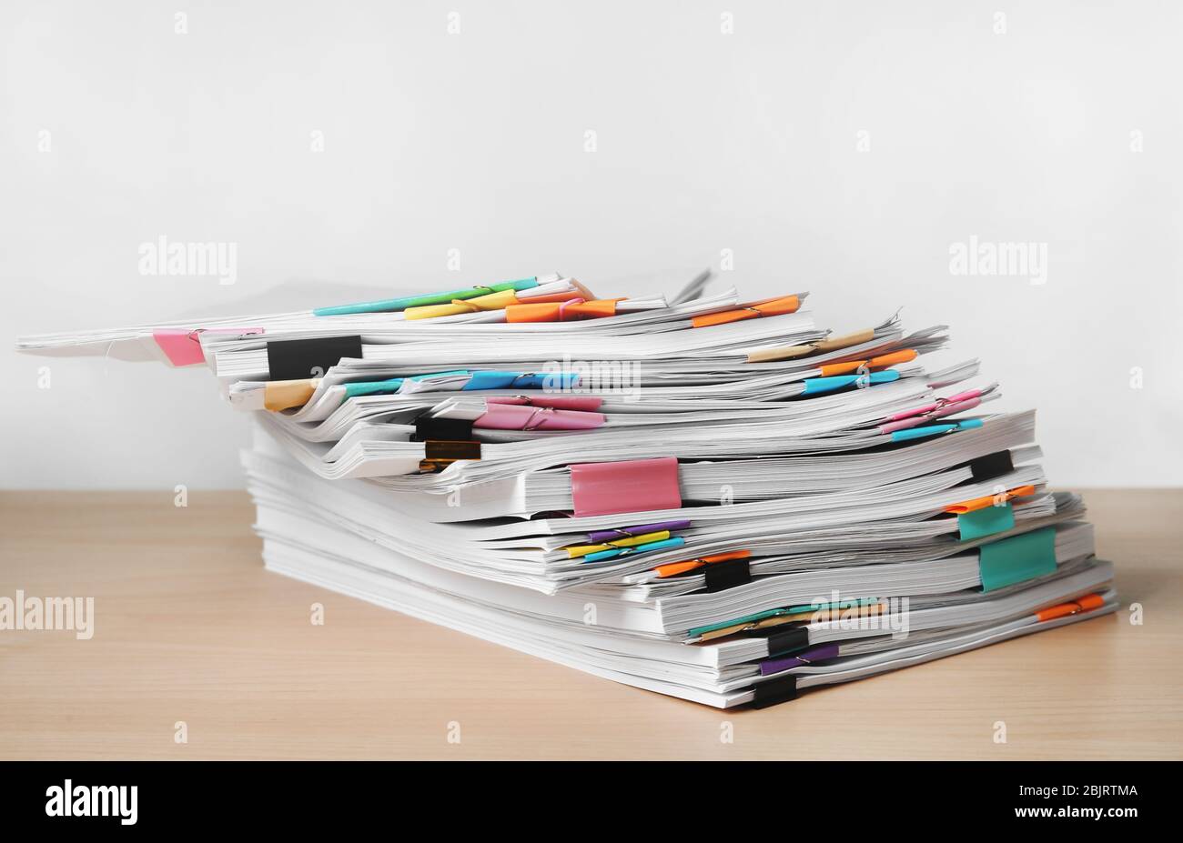 Stack of documents on table against white background Stock Photo - Alamy