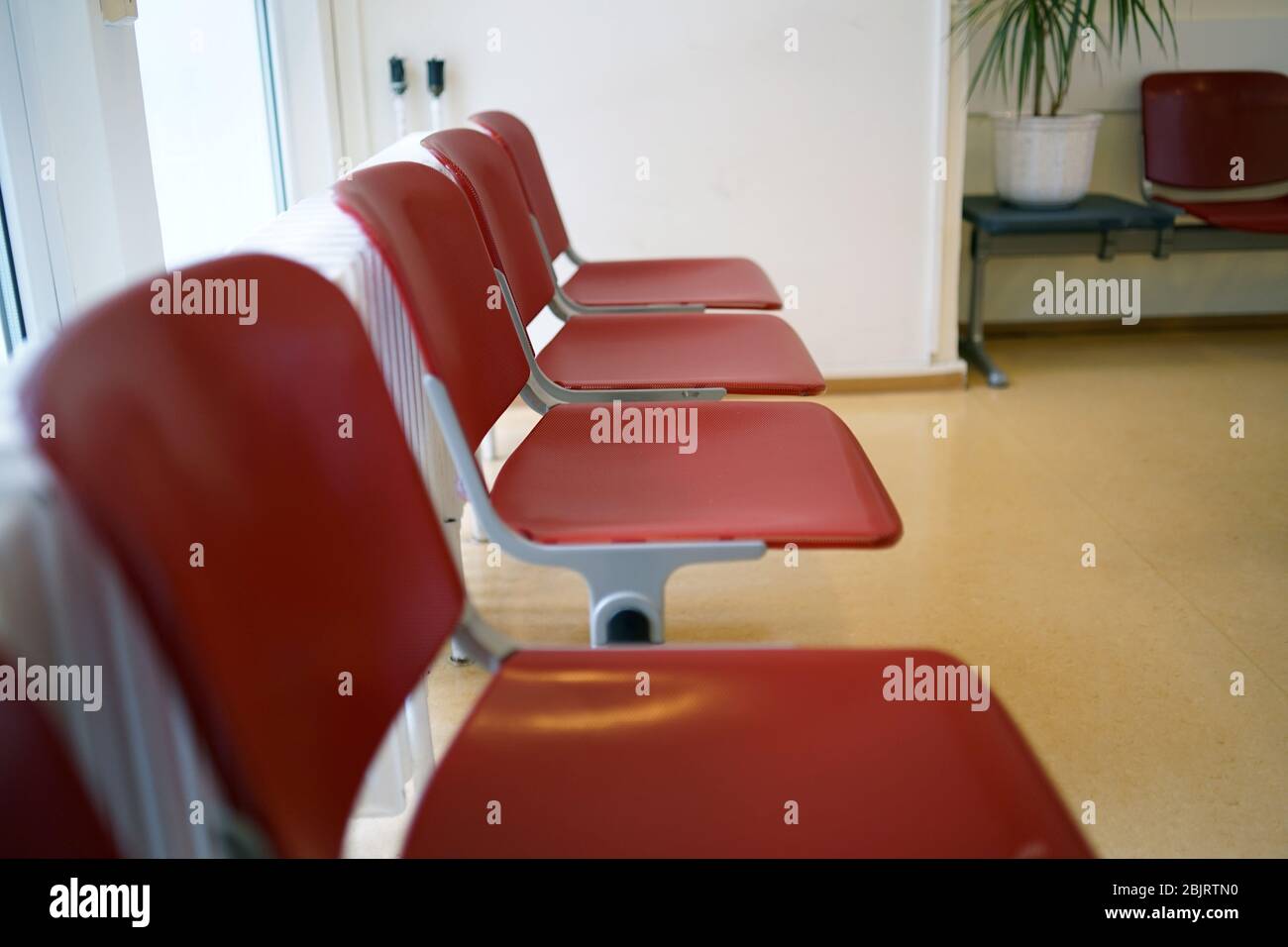Waiting room with red chairs and beige linoleum floor Stock Photo - Alamy