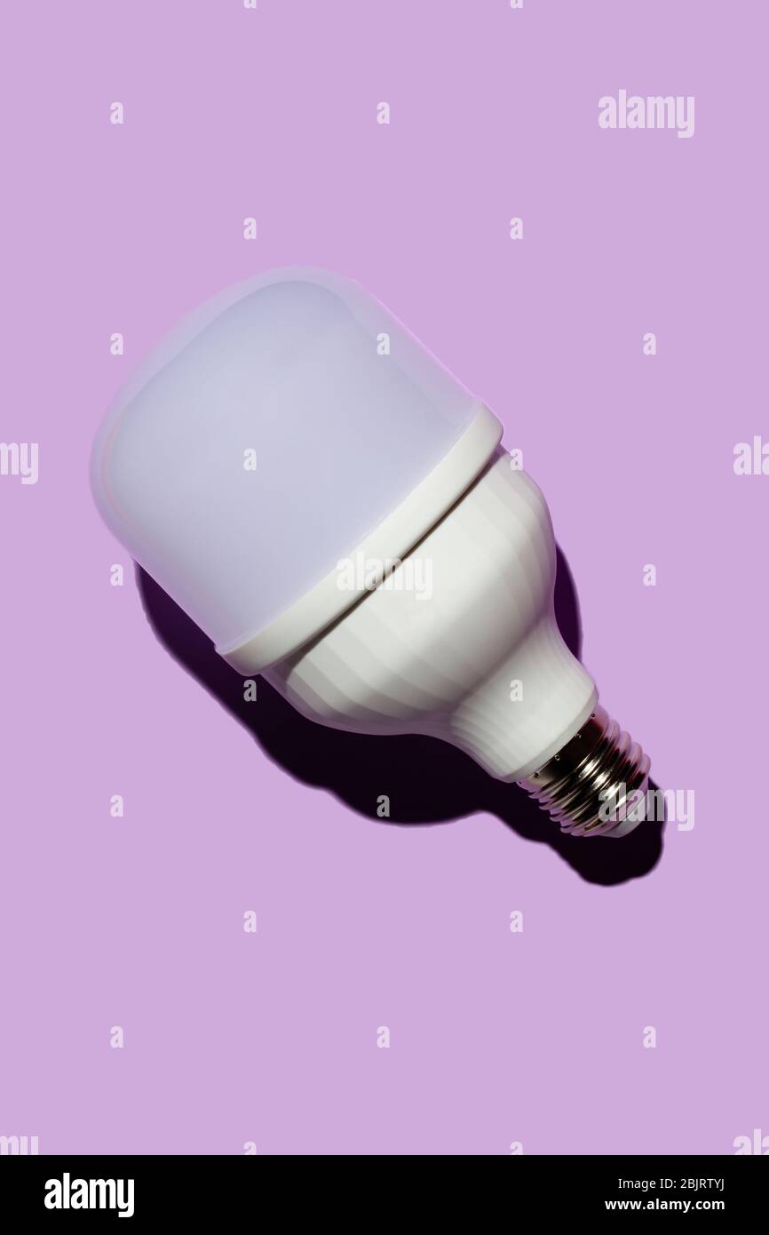 LED light bulb with hard shadows on a purple background Stock Photo - Alamy
