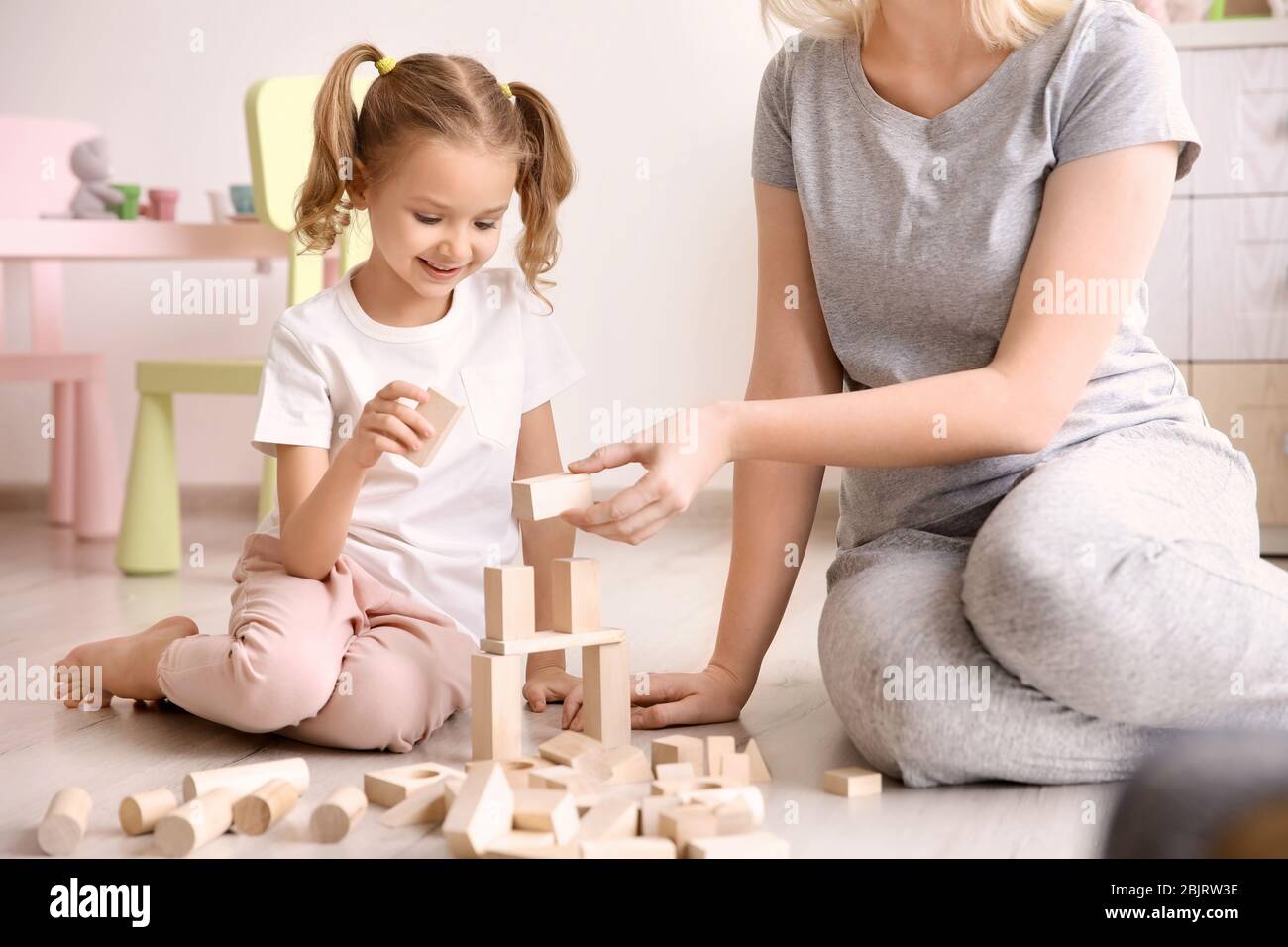 Mother and cute little girl playing with building blocks at home Stock ...