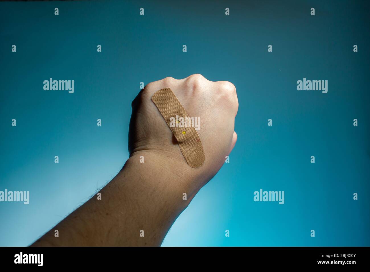 medical plaster on the hand wound, cut on a blue background copy space ...