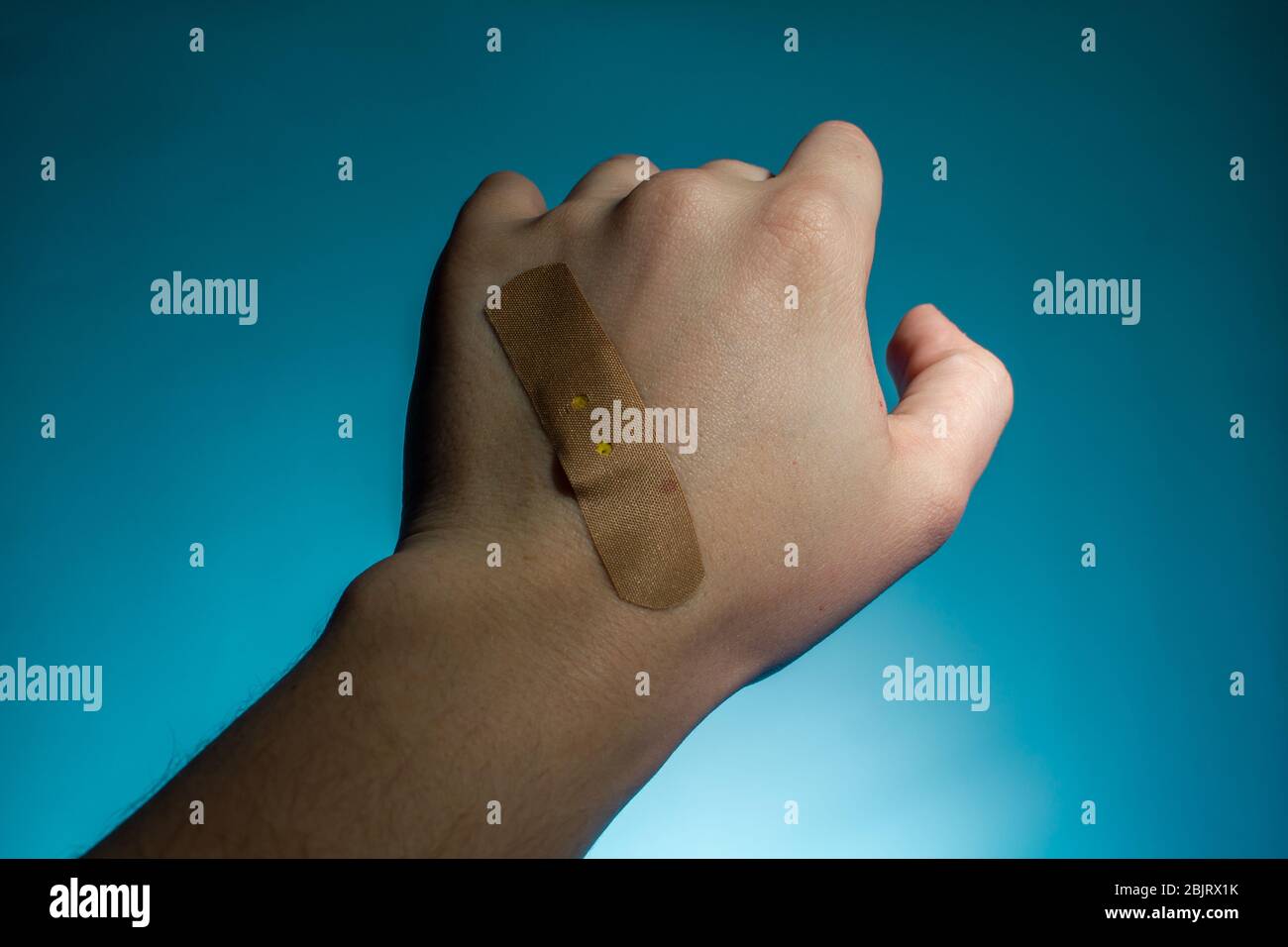 medical plaster on the hand wound, cut on a blue background copy space ...