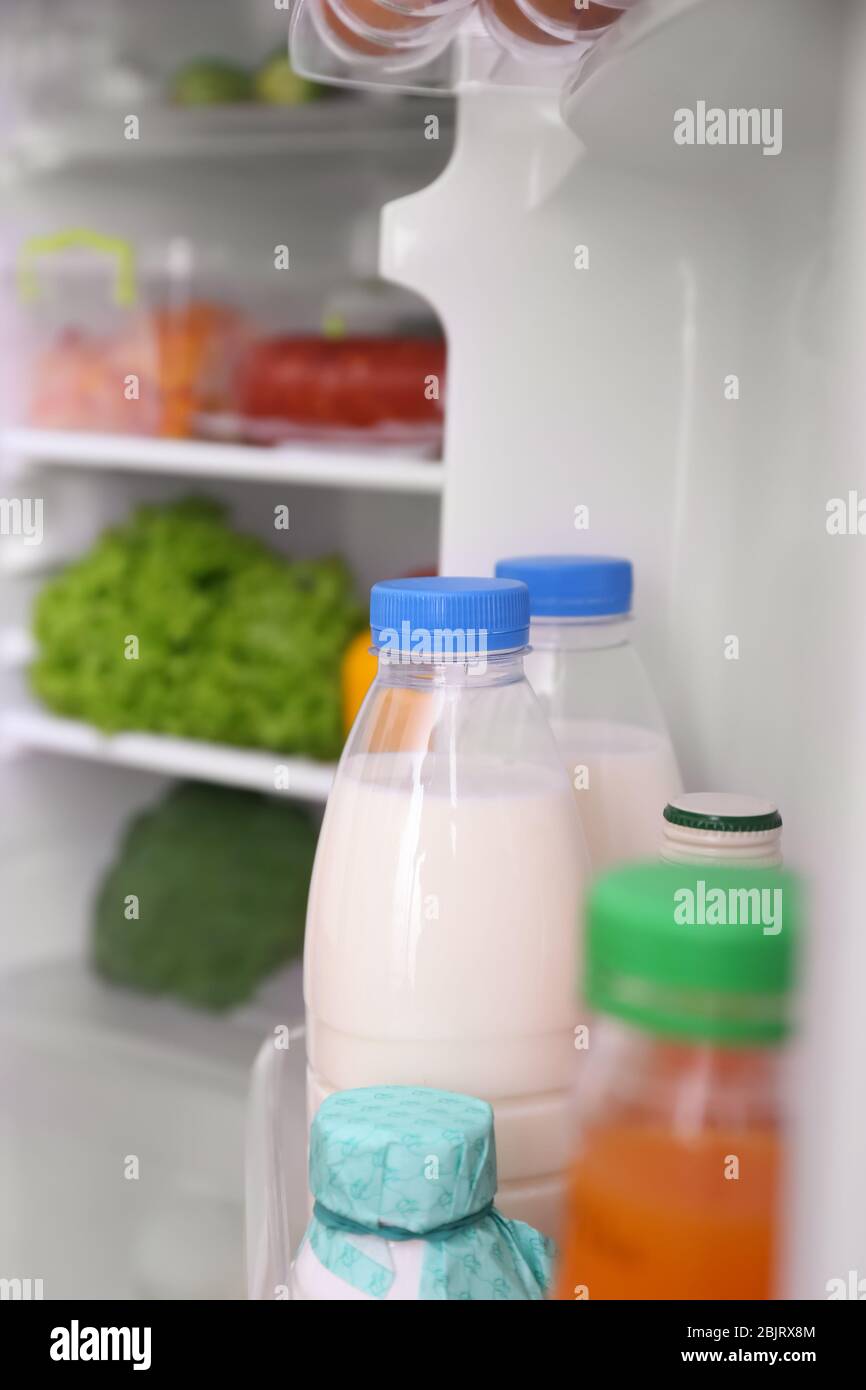 Bottles with milk on refrigerator shelf, closeup Stock Photo - Alamy
