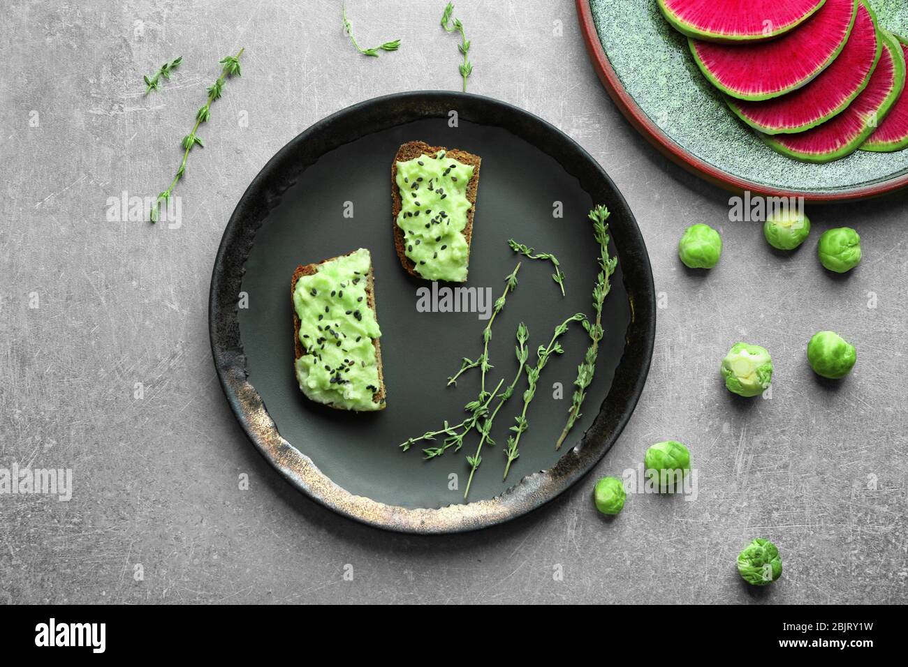 Ceramic plate with sandwiches on grey background Stock Photo - Alamy