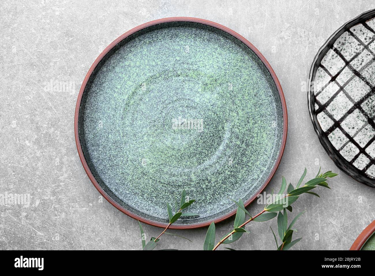 Ceramic plate on grey background Stock Photo - Alamy