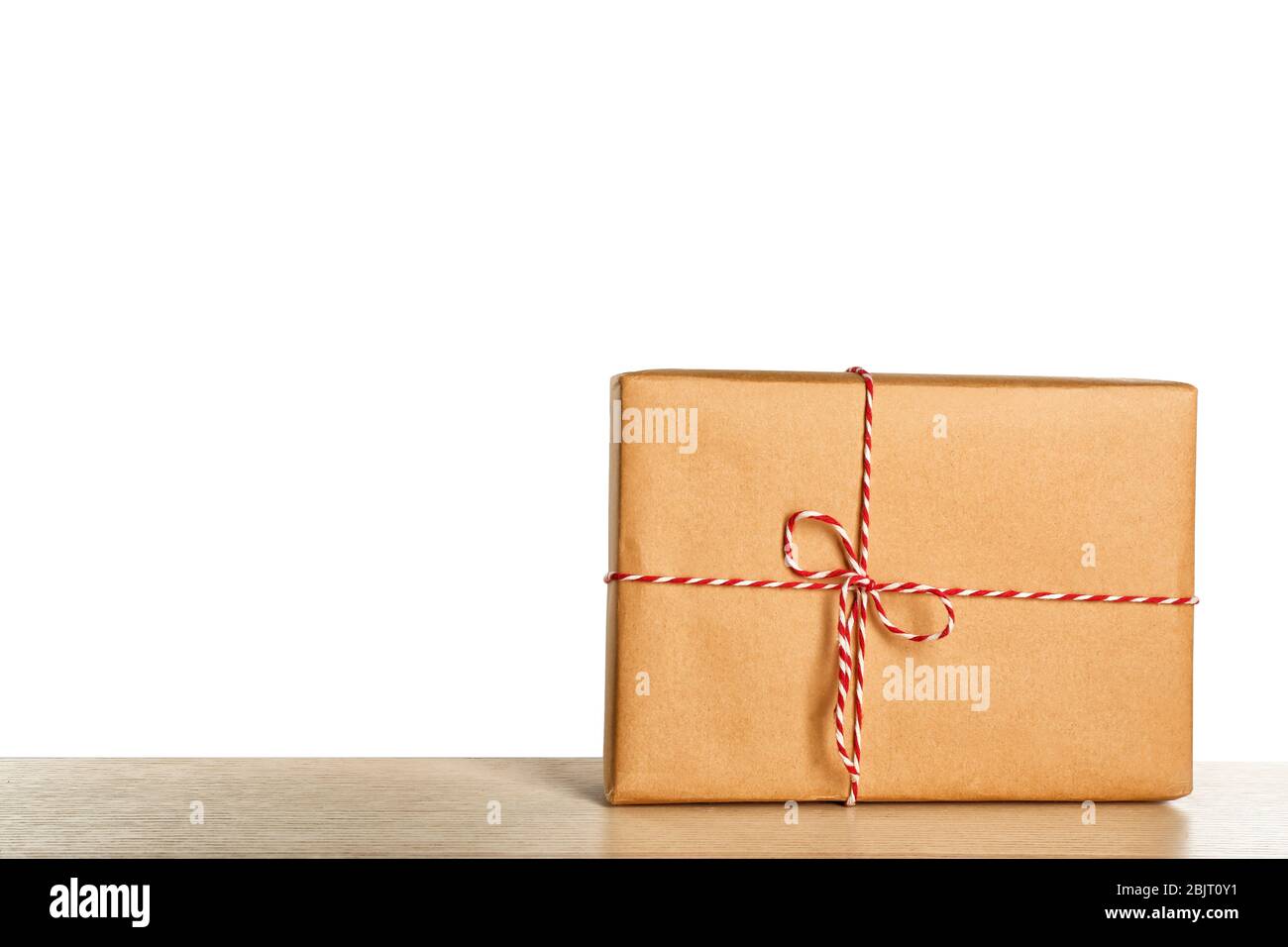 Parcel gift box on table against white background Stock Photo - Alamy