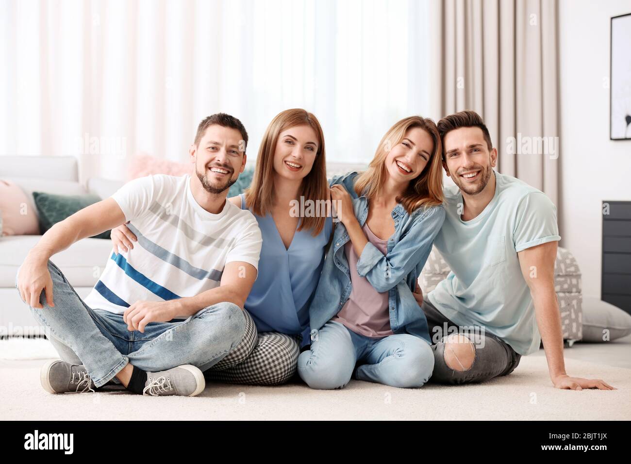 Group of happy young people resting indoors Stock Photo - Alamy