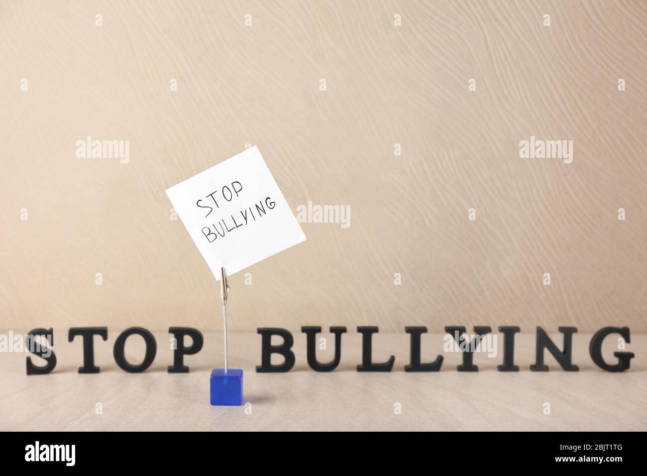 Note with text "Stop bullying" on pad holder against light background ...