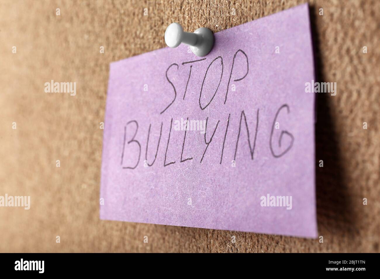 Note with text "Stop bullying" pinned to board Stock Photo - Alamy