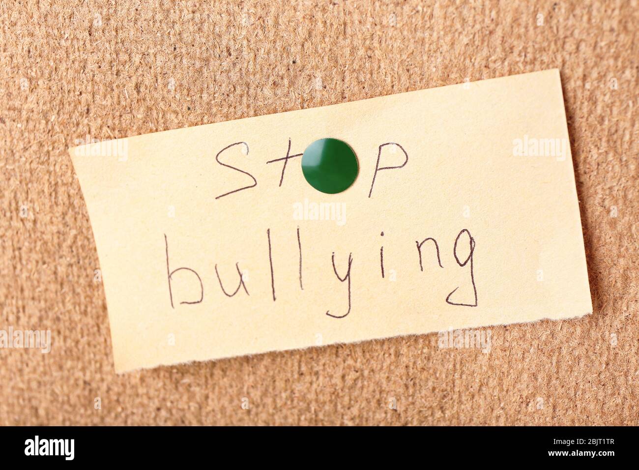 Note with text "Stop bullying" pinned to board Stock Photo - Alamy