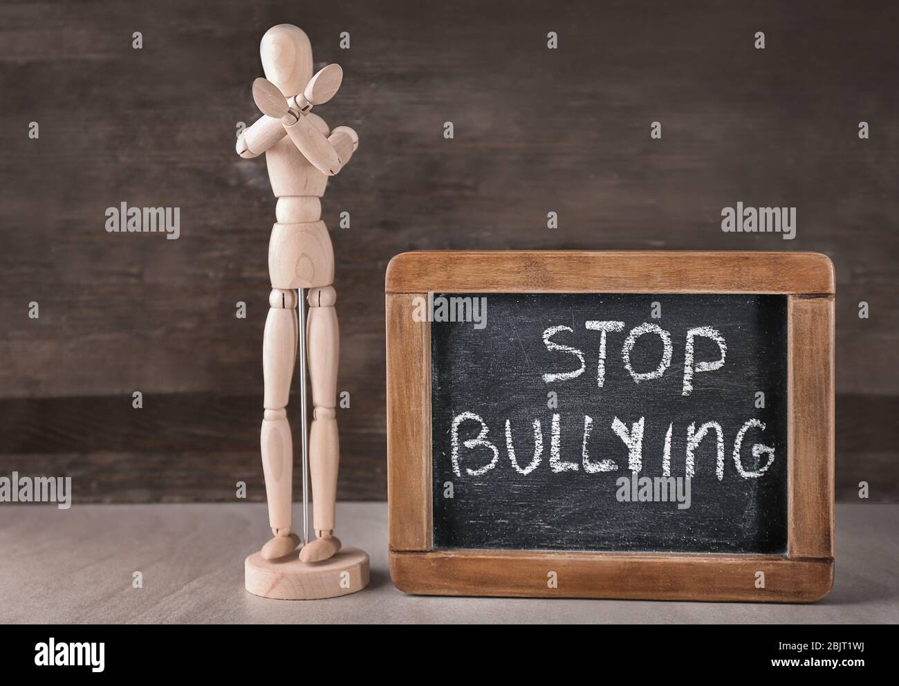 Wooden figure and chalkboard with text "Stop bullying" on table Stock ...