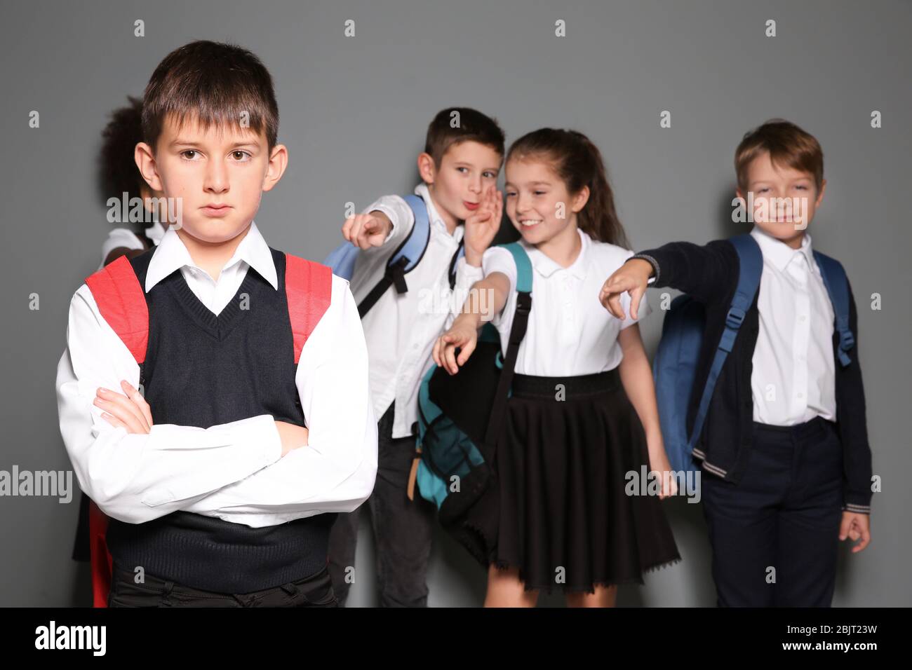 Children bullying their classmate on grey background Stock Photo - Alamy