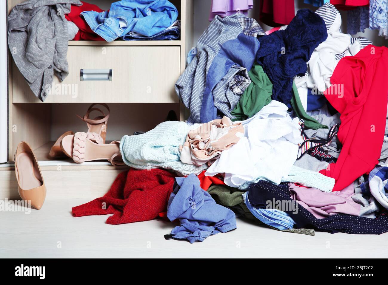 Pile of clothes on floor indoors Stock Photo - Alamy