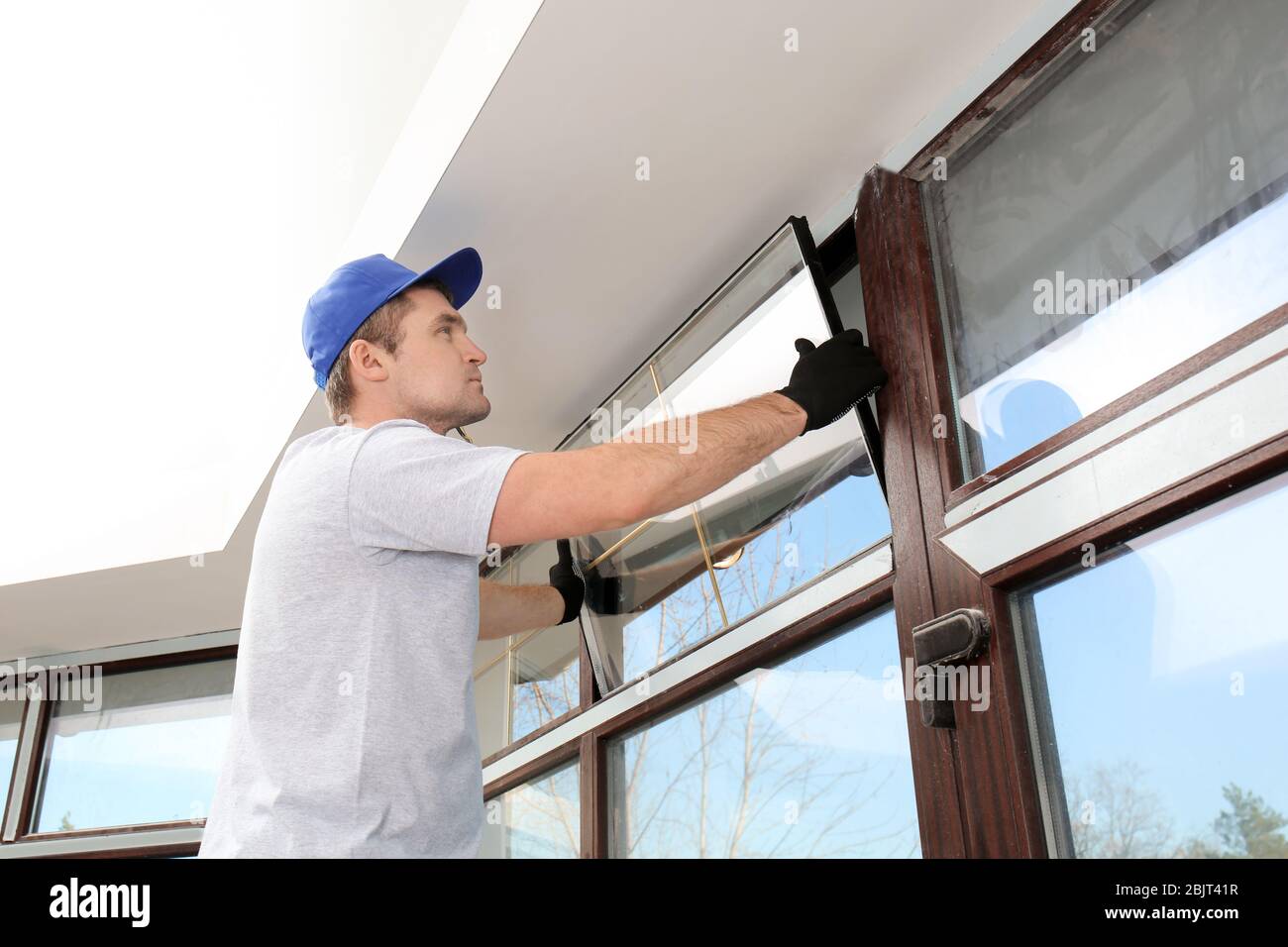 Construction worker repairing window in house Stock Photo - Alamy