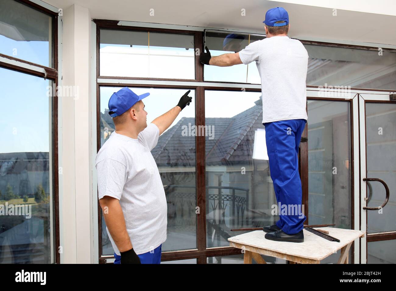 Construction workers repairing window in house Stock Photo - Alamy