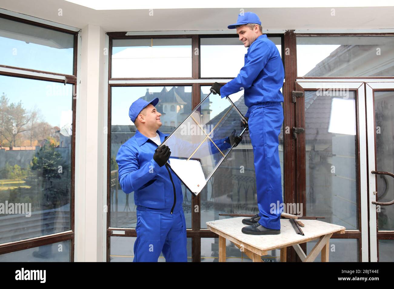 Construction workers repairing window in house Stock Photo - Alamy