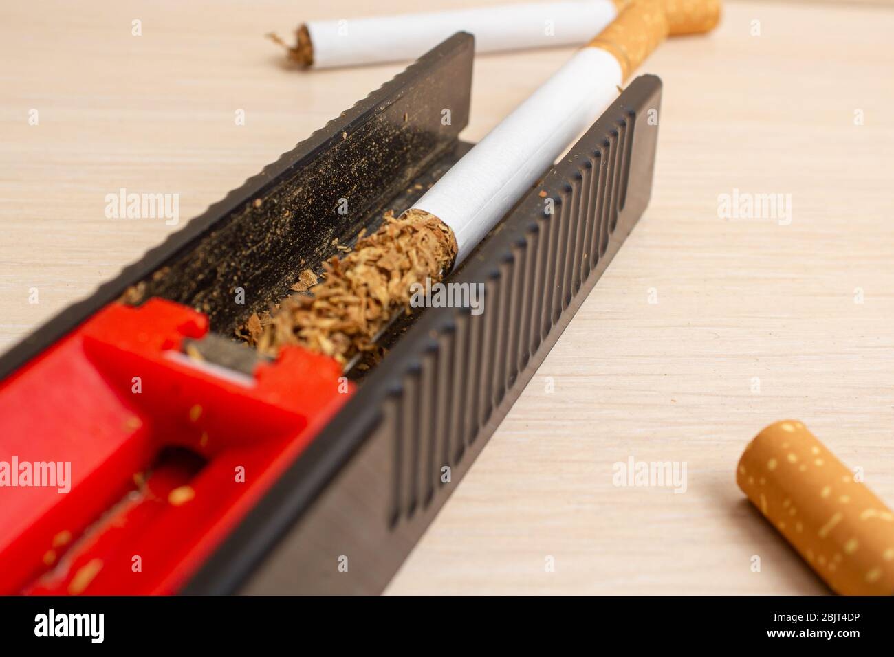 machine for stuffing cigarettes and cigarettes in the background on a ...