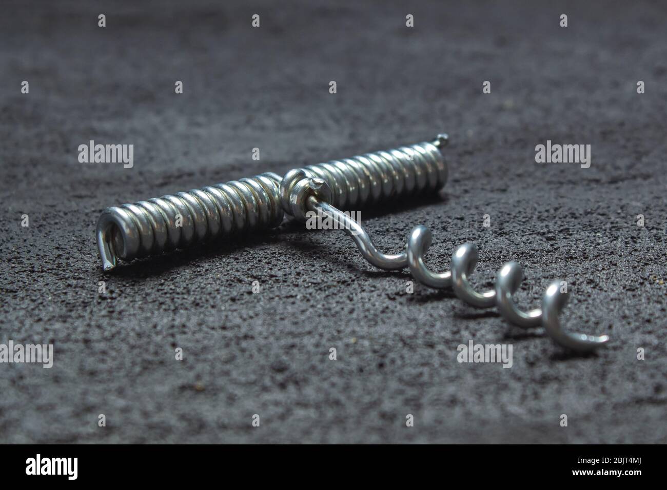metal corkscrew on black concrete Stock Photo - Alamy