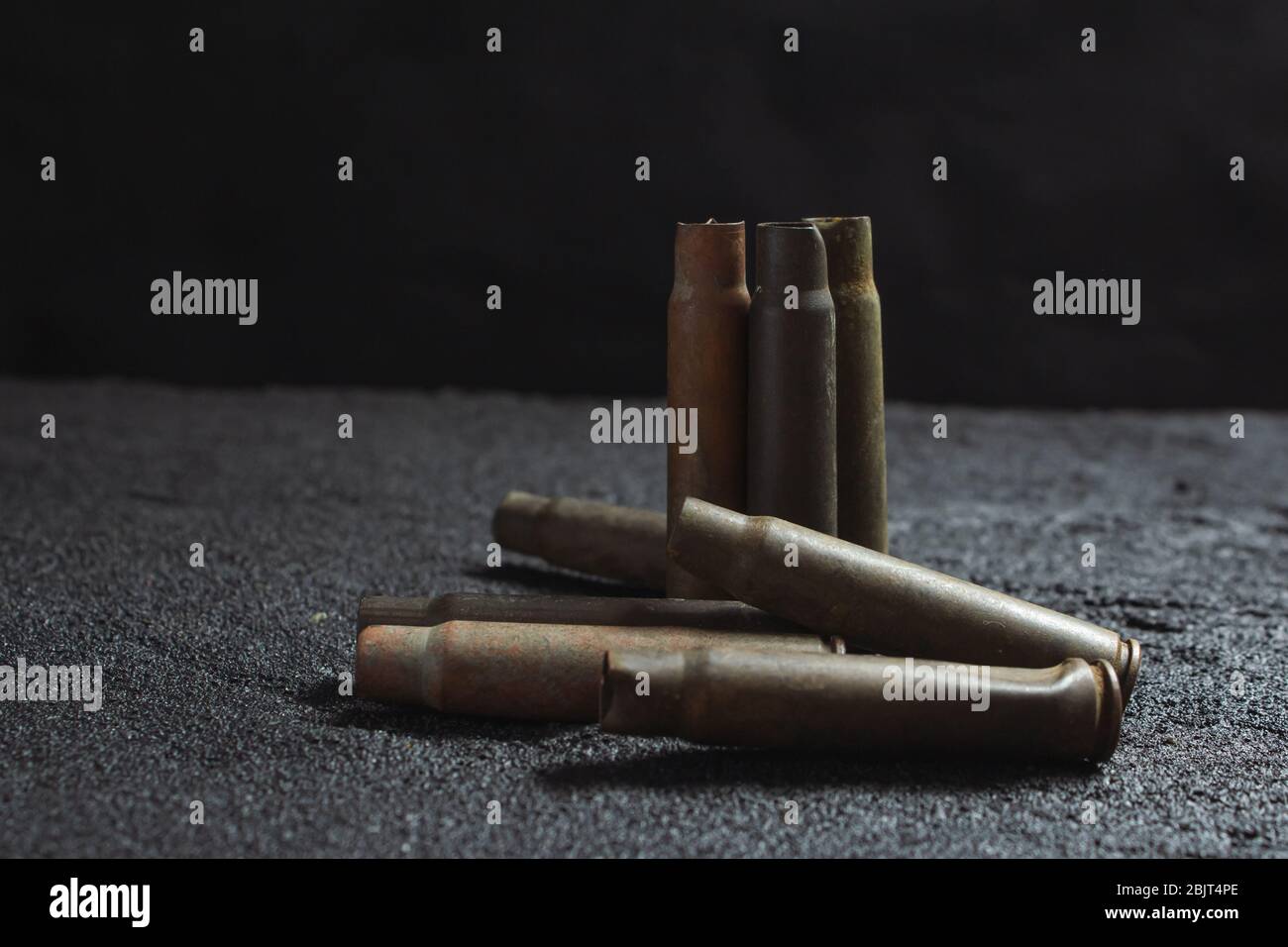 old rusty spent shells on black concrete Stock Photo - Alamy