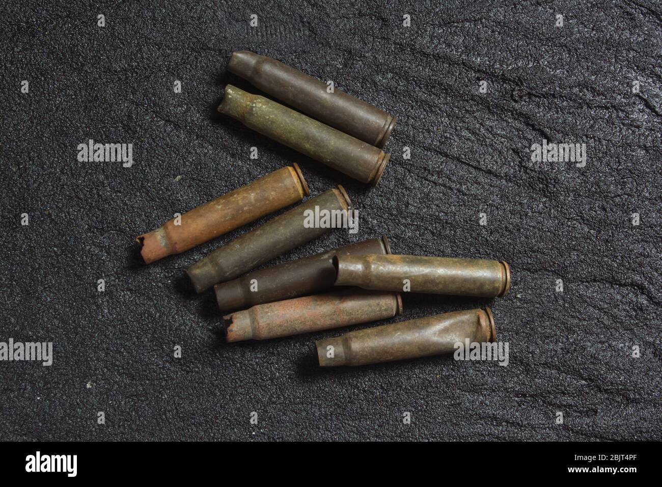 old rusty spent shells on black concrete Stock Photo - Alamy
