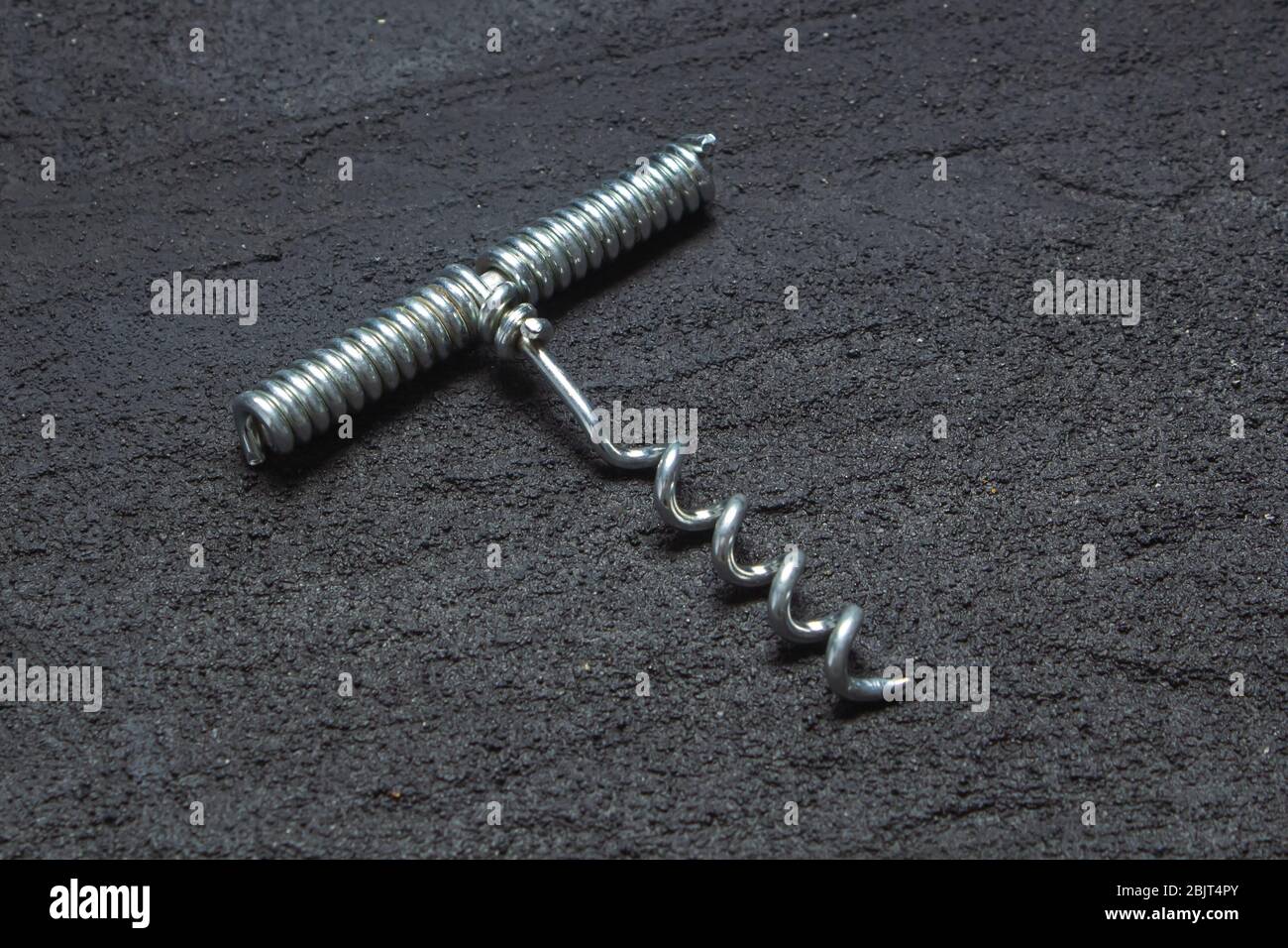 metal corkscrew on black concrete Stock Photo - Alamy