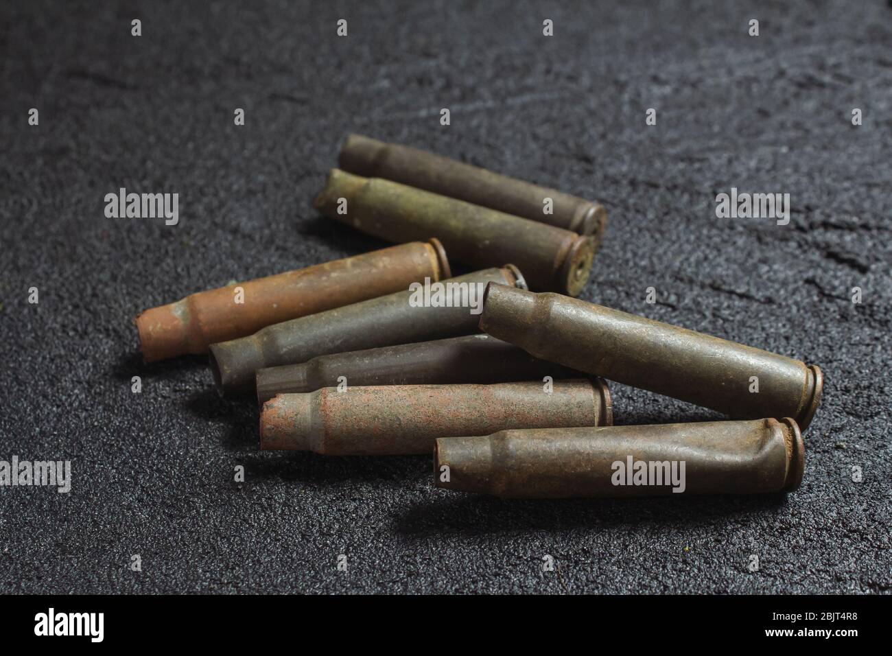 old rusty spent shells on black concrete Stock Photo - Alamy