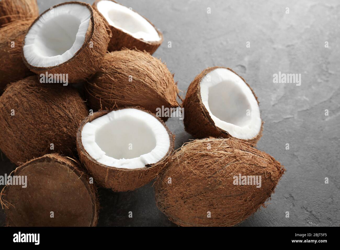 Pile of coconuts on grey background Stock Photo - Alamy