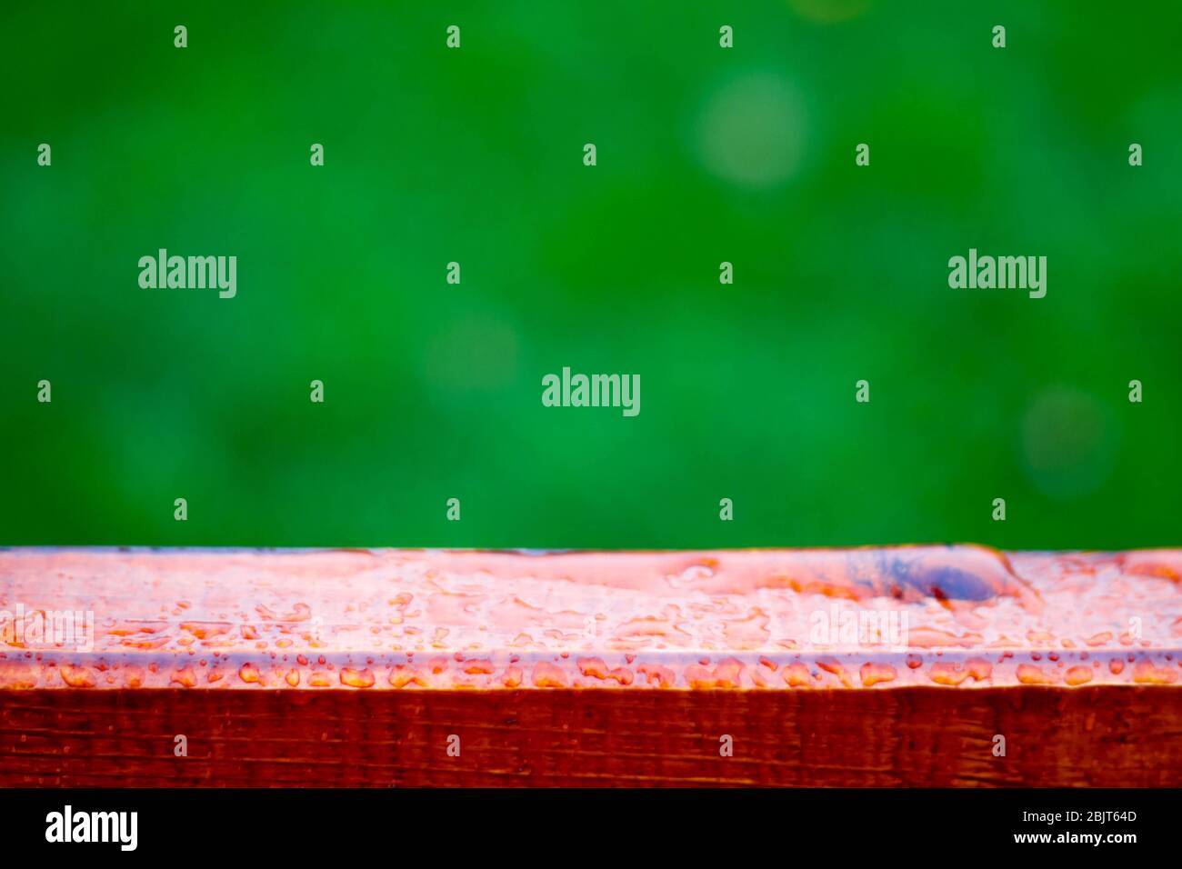Wet wood block with blurry green background Stock Photo - Alamy